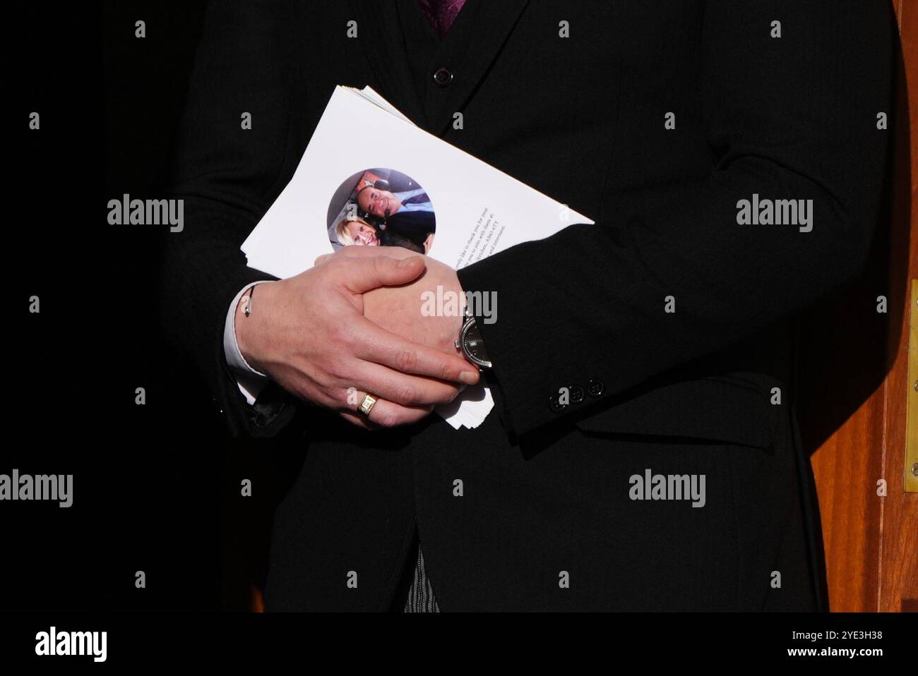 A man holds the order of service, with an image of Alex Salmond and his ...