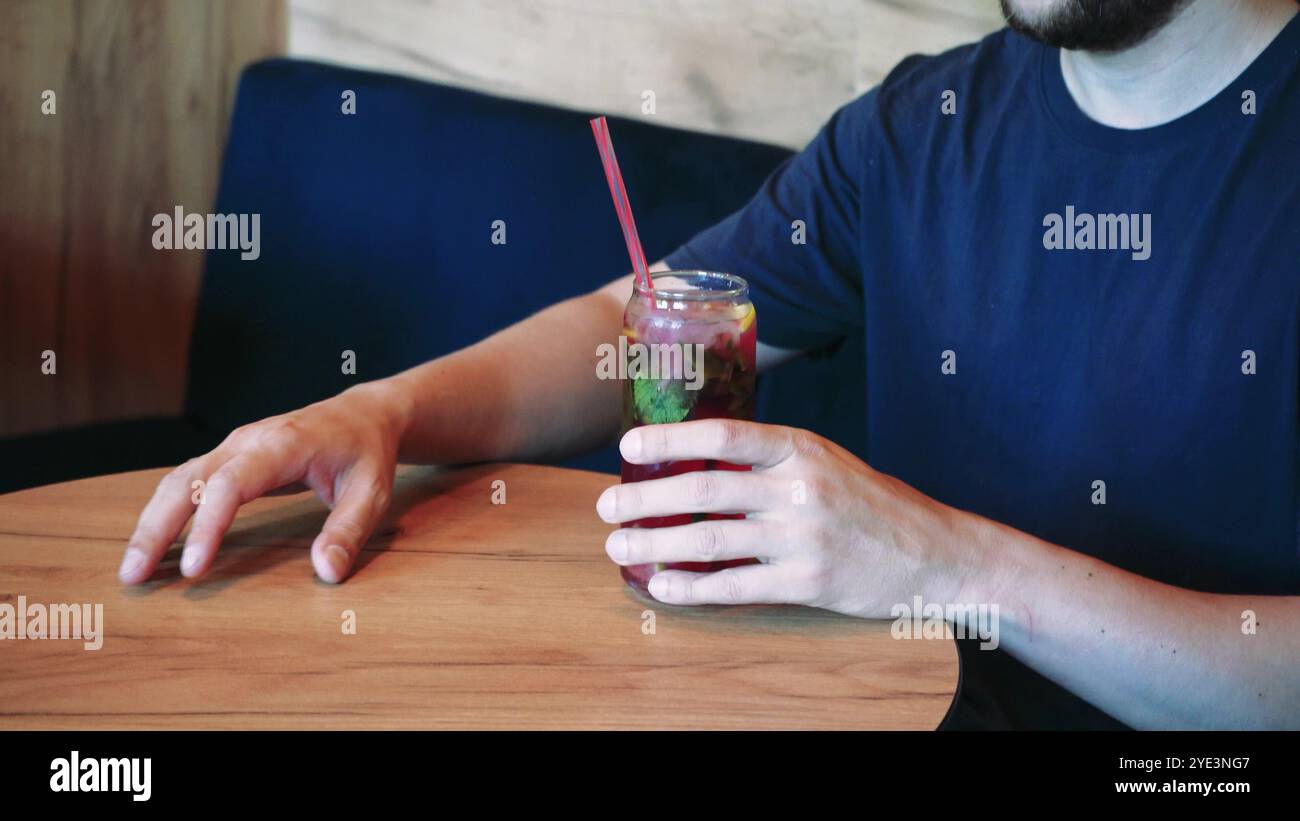 A peaceful scene unfolds as the man relaxes over a summer drink. His ...