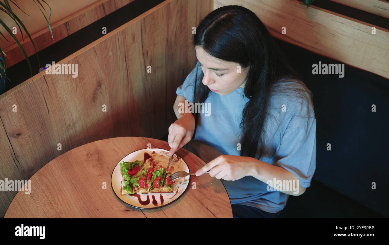 A serene moment of mindful eating as a woman enjoys her healthy meal at ...