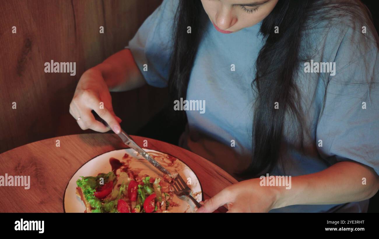 A serene moment of mindful eating as a woman enjoys her healthy meal at ...