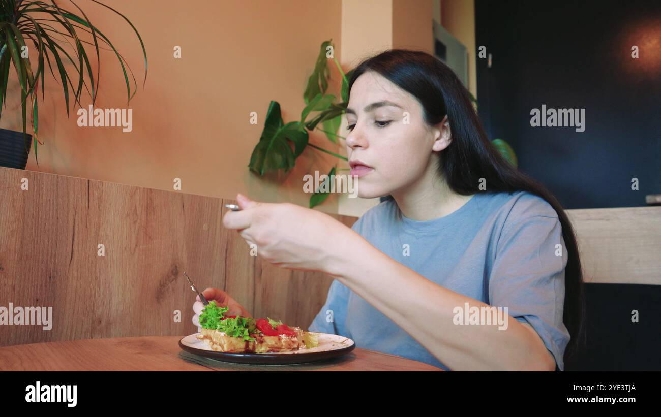 A peaceful indoor dining scene, featuring a woman enjoying a light meal ...