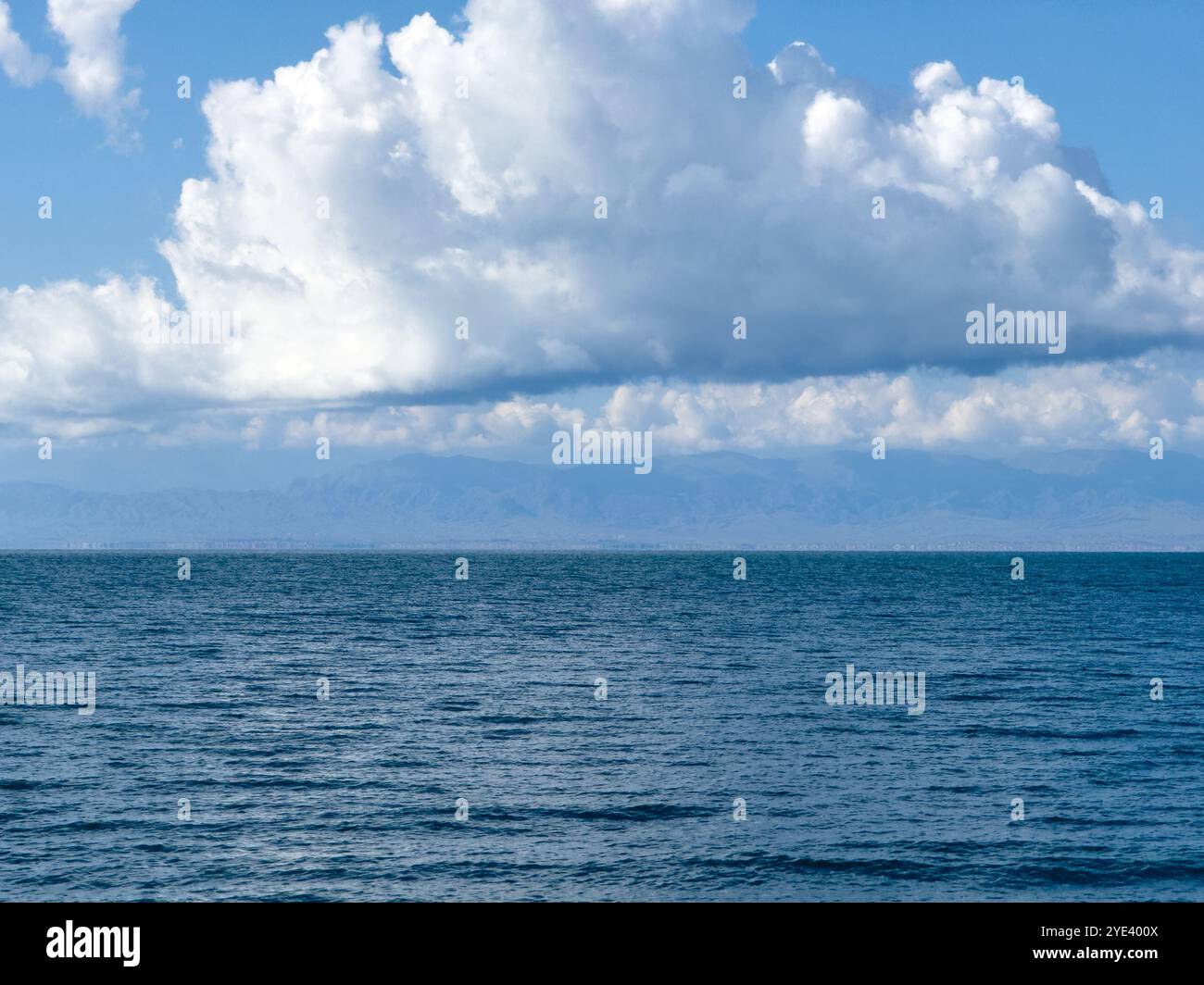 Issyk-Kul Lake with a cloudy sky and mountains in the background. The ...
