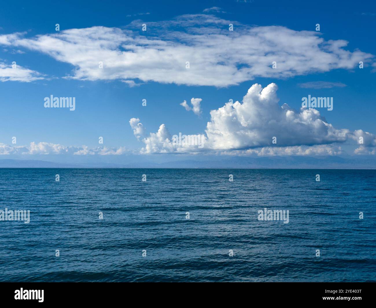 Issyk-Kul Lake with a cloudy sky and mountains in the background. The ...