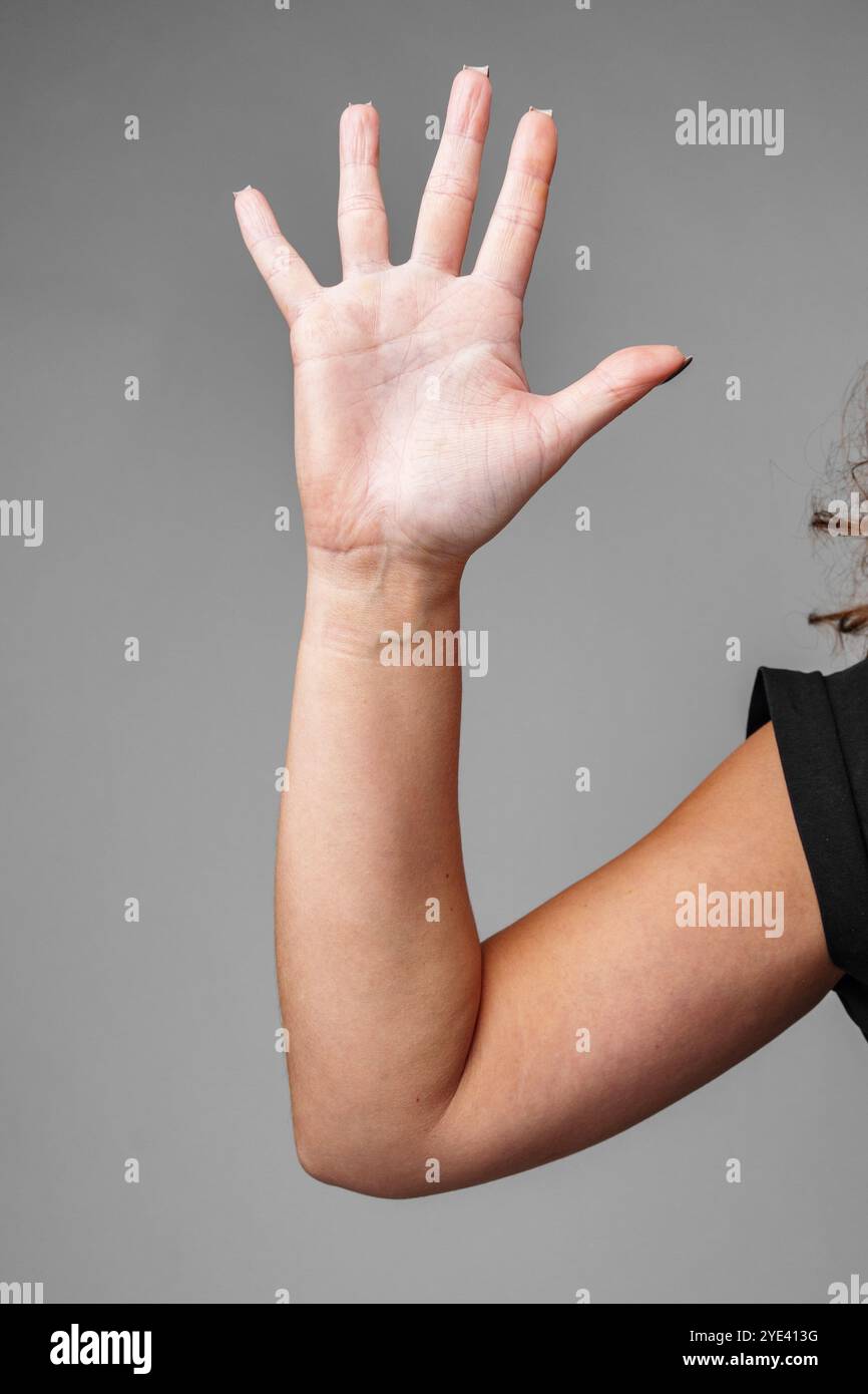 A raised hand demonstrating a gesture of greeting with a neutral ...