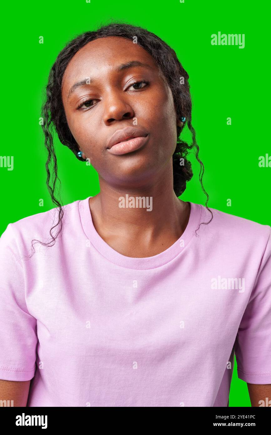 Young woman with an expression of contemplation poses against a bright ...