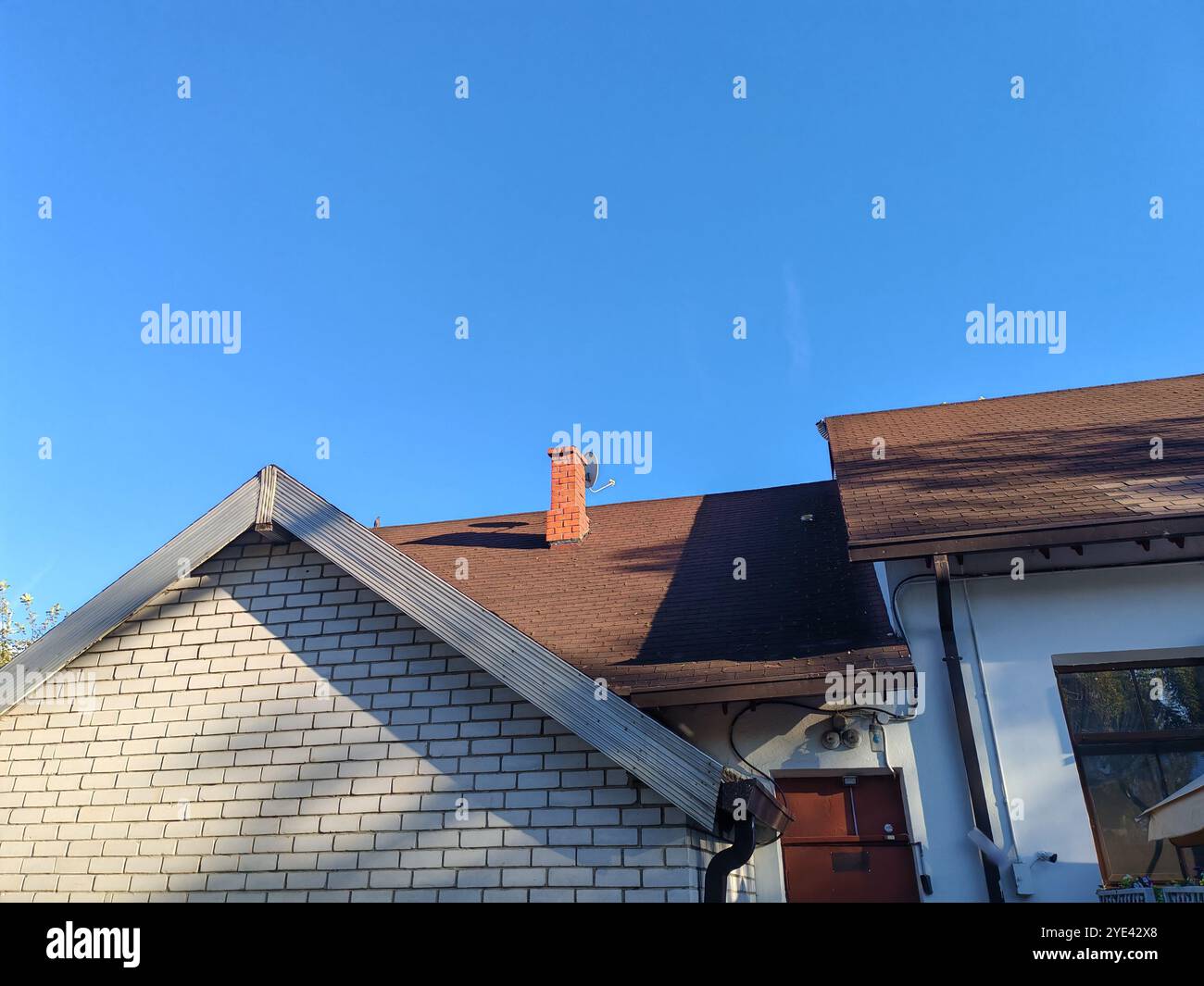 A home featuring a sloped metal roof and wooden elements, set against ...