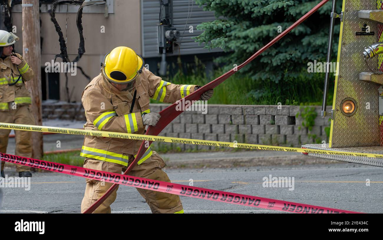 Firefighter pulling out a red fire hose from a fire truck Stock Photo ...