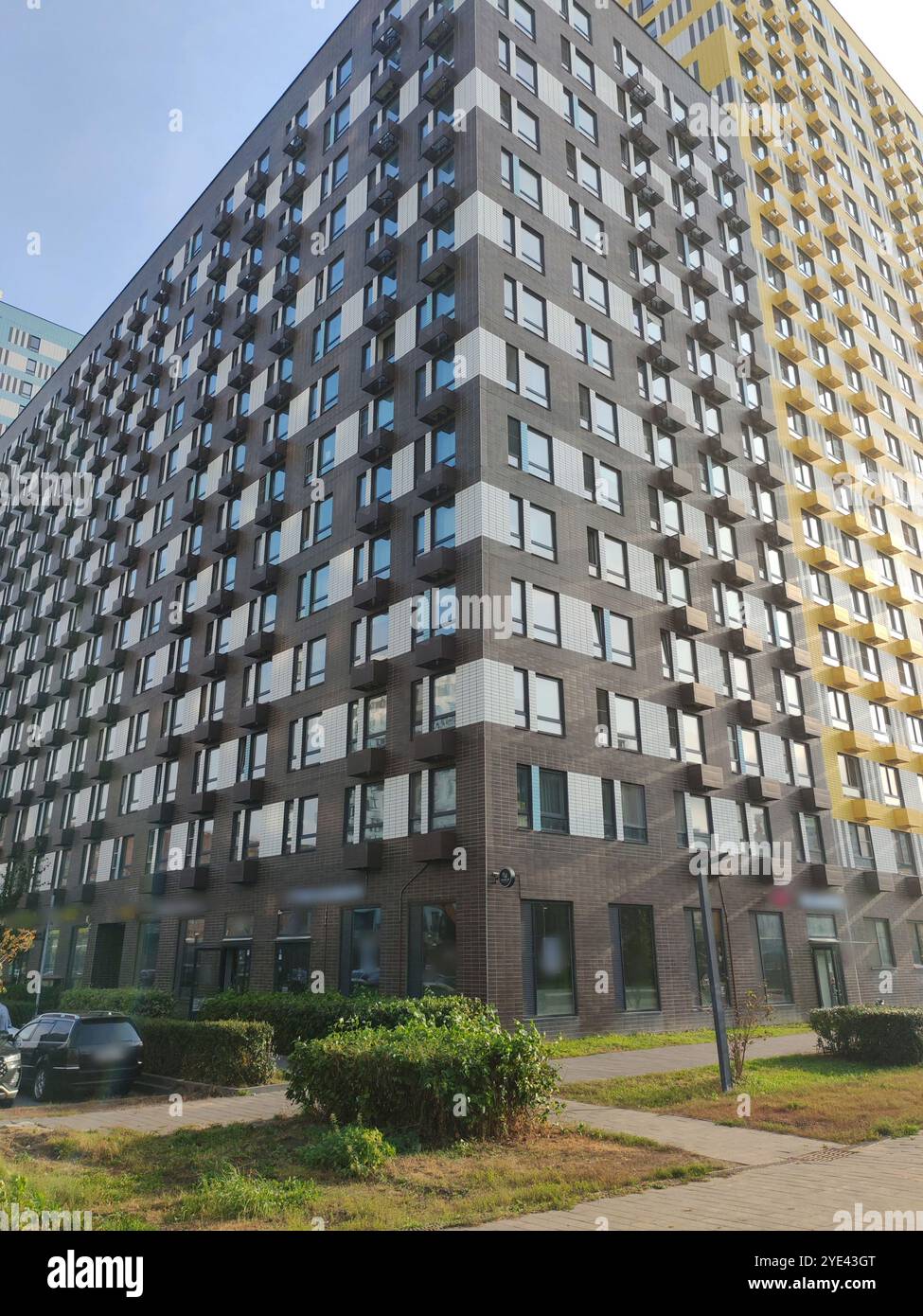 pair of tall apartment buildings with bold color schemes—one in yellow ...