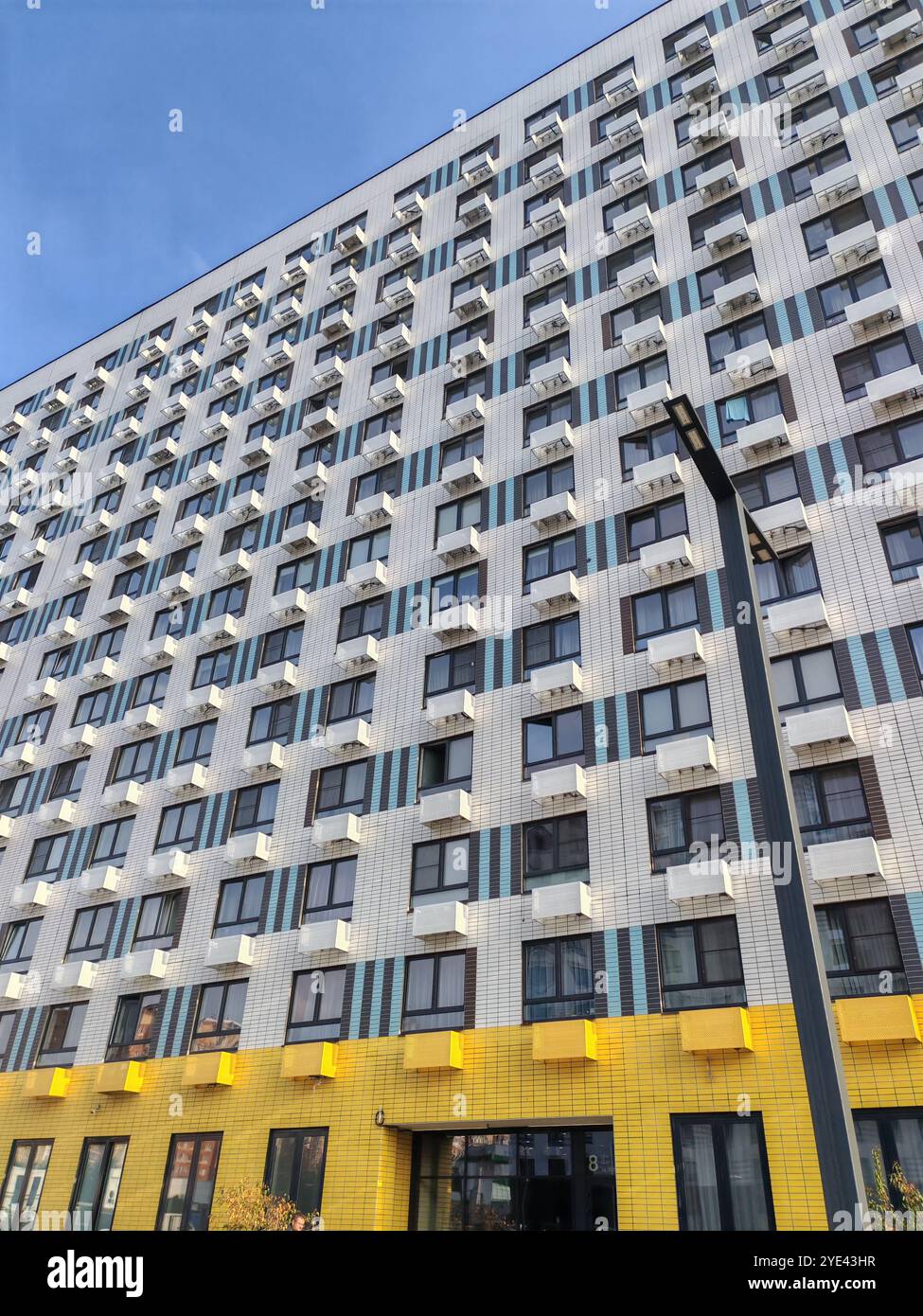 Two high-rise buildings featuring a dynamic contrast of yellow and ...