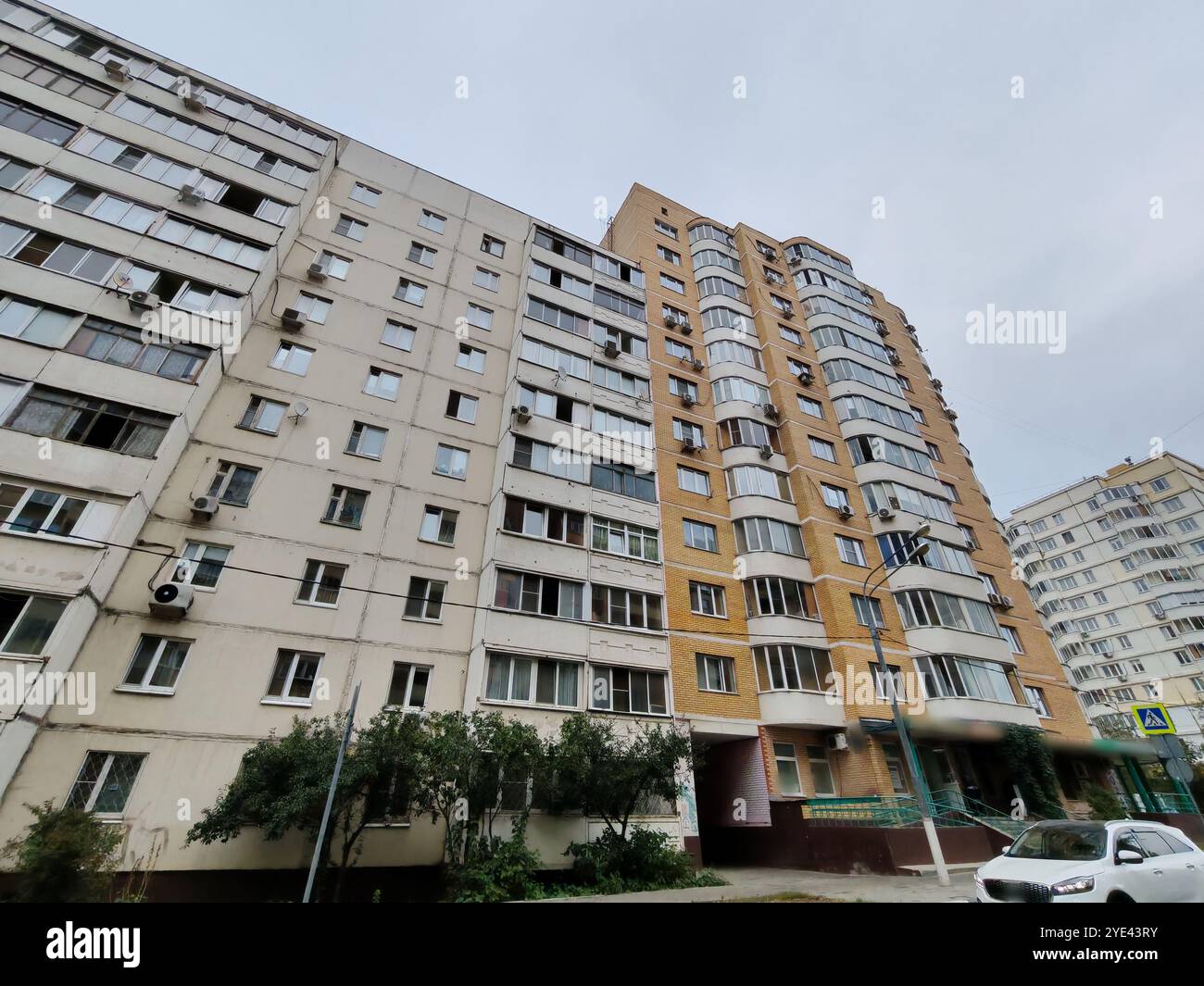 A pastel-colored high-rise residential building with curved balconies ...