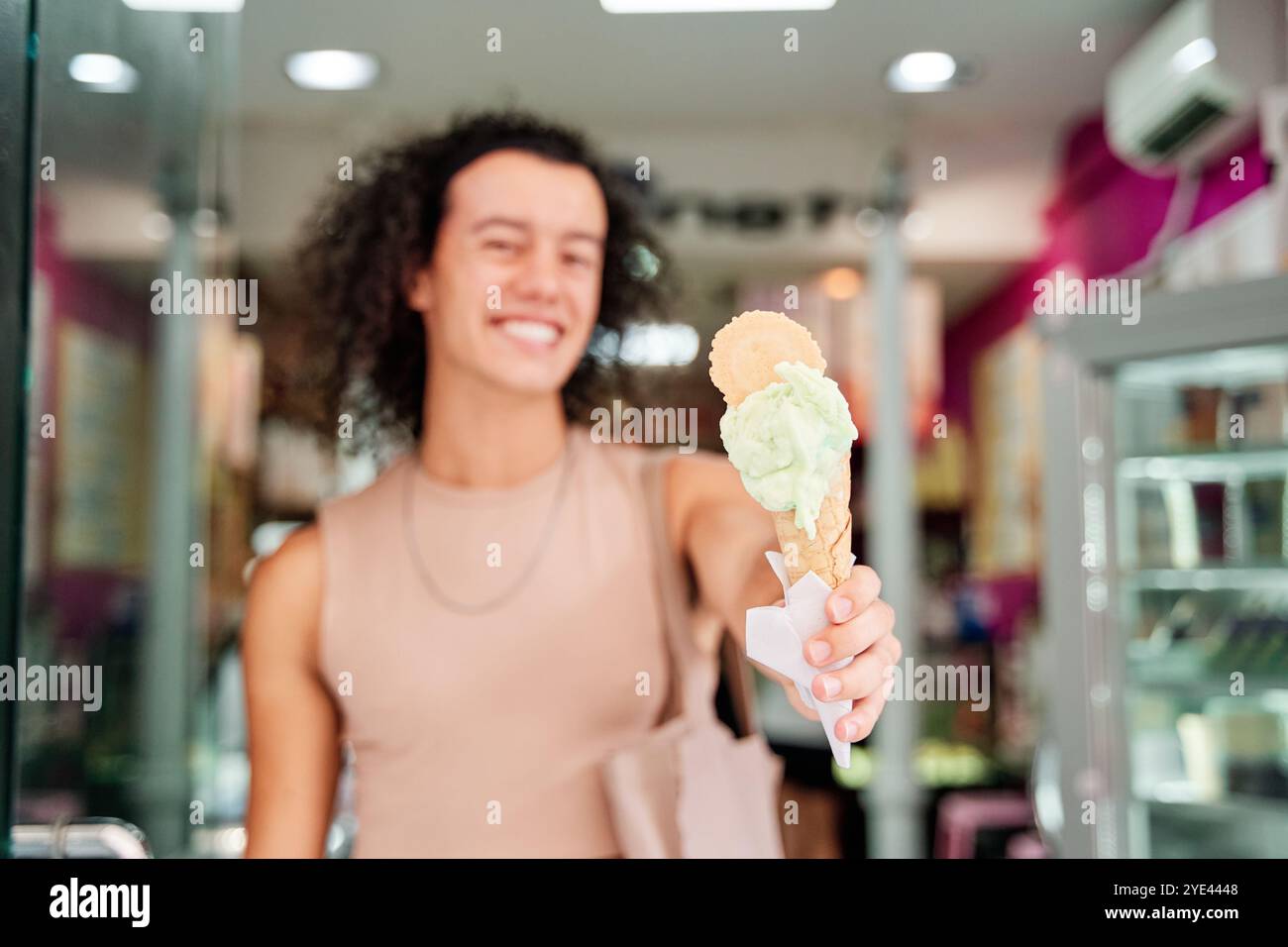a handsome young white man holding and eating a gelato ice cream in a ...