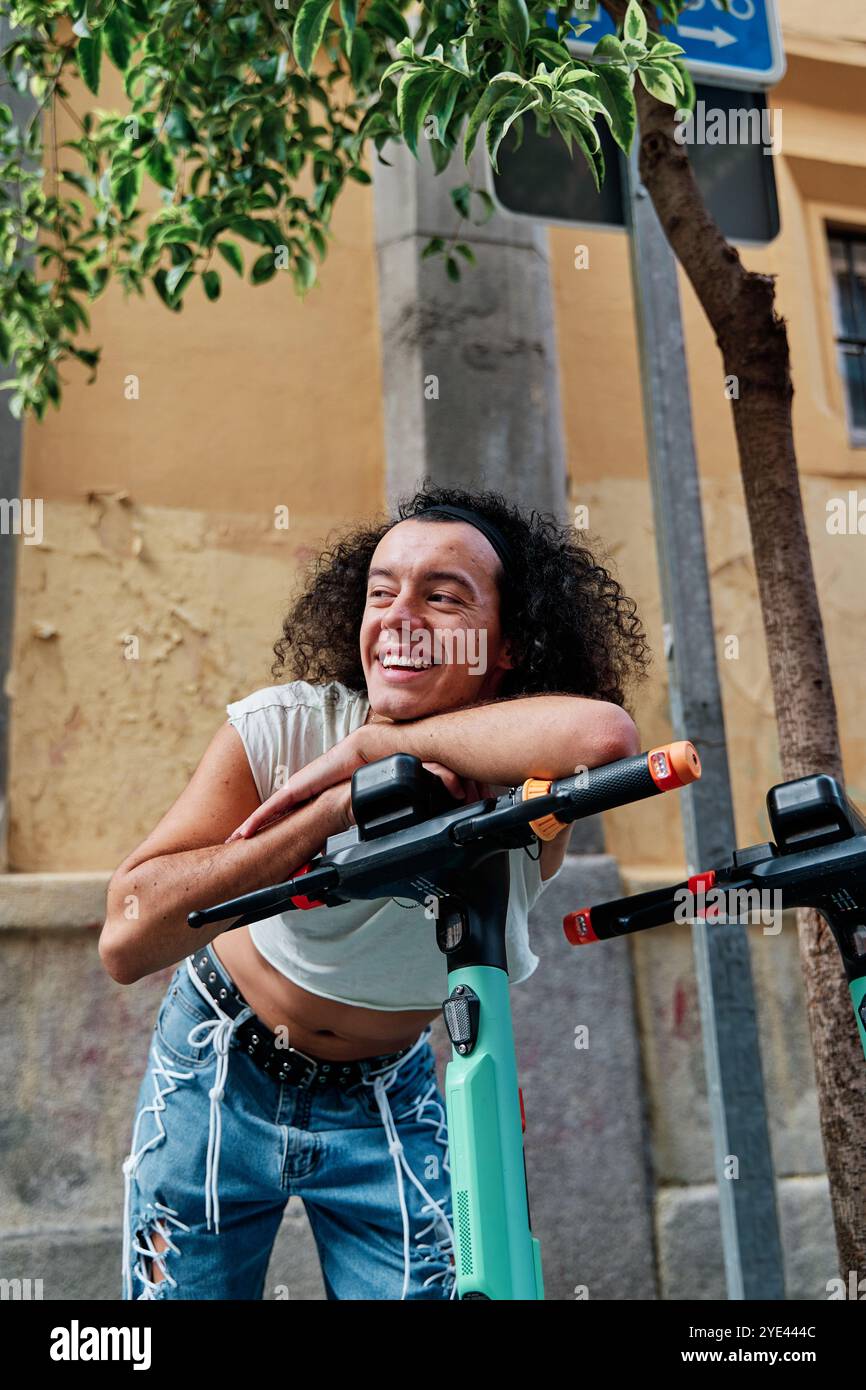 portrait of a man with curly hair getting on his motorcycle with a huge ...