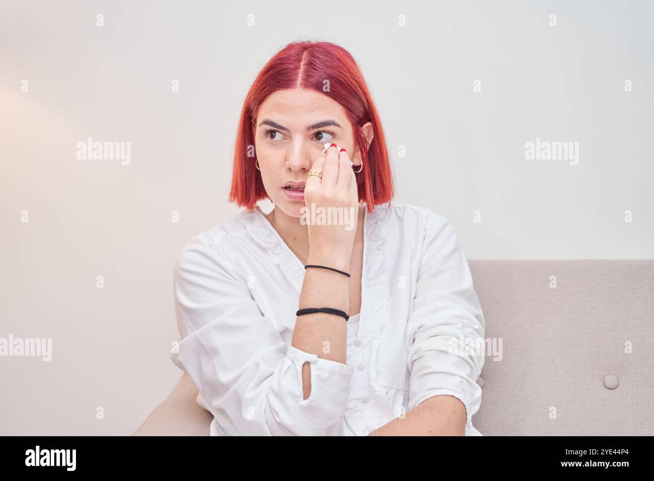 red-haired woman in psychologist's office crying. young woman wiping ...