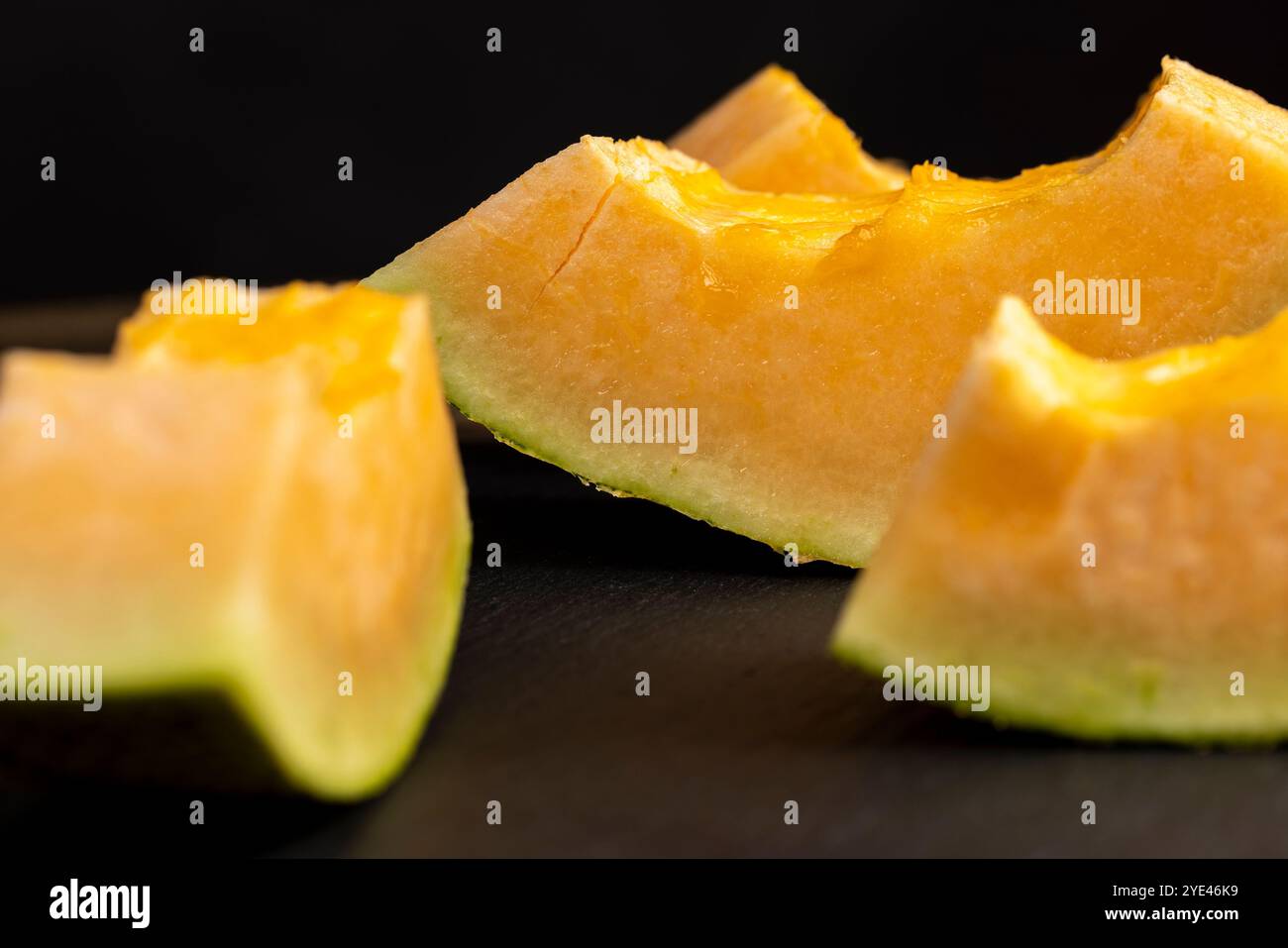 fresh melon cut into pieces closeup, slicing sweet orange melon into ...