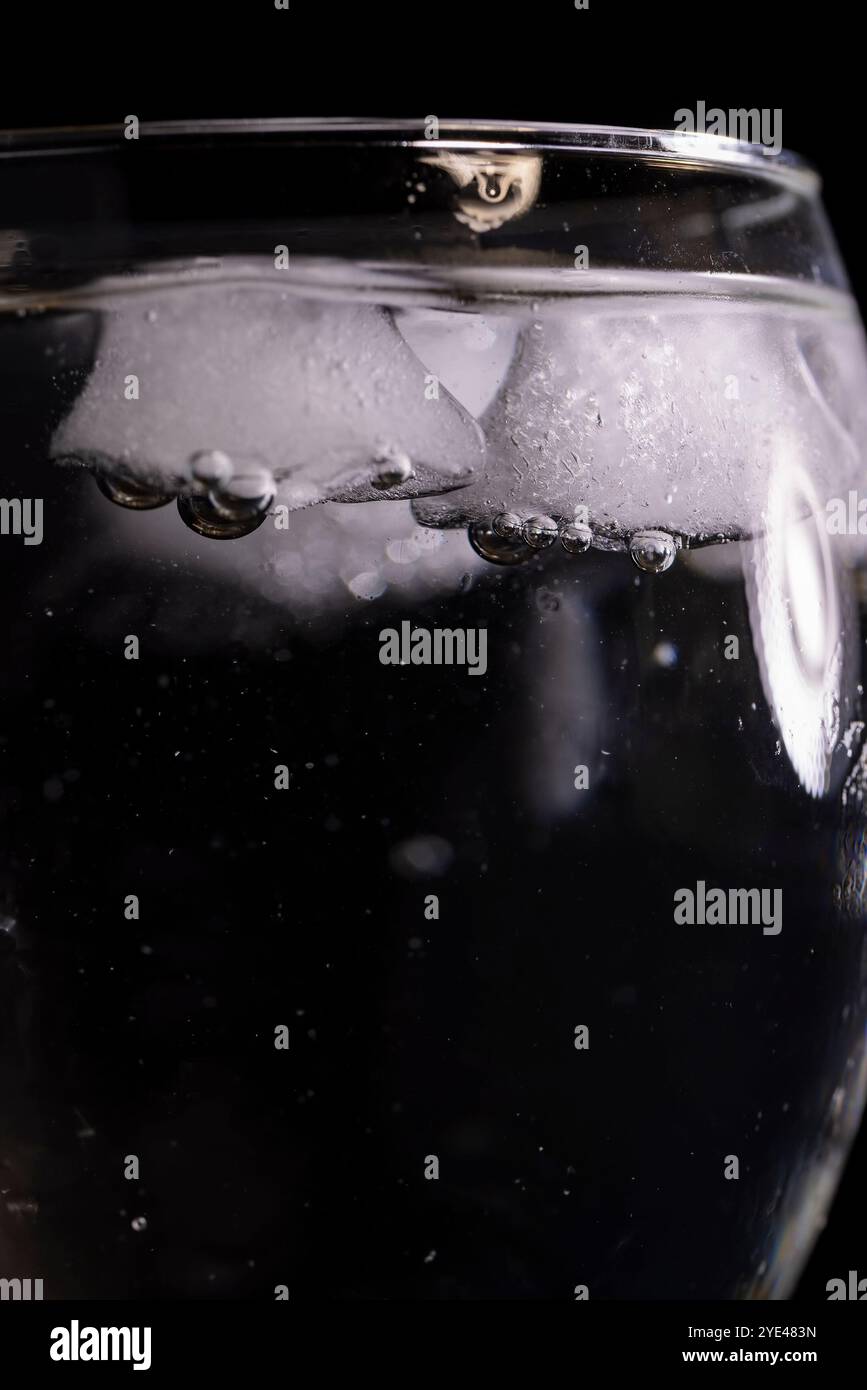 glass with cold sparkling water closeup, cold mineral water with a lot of gases and bubbles ...