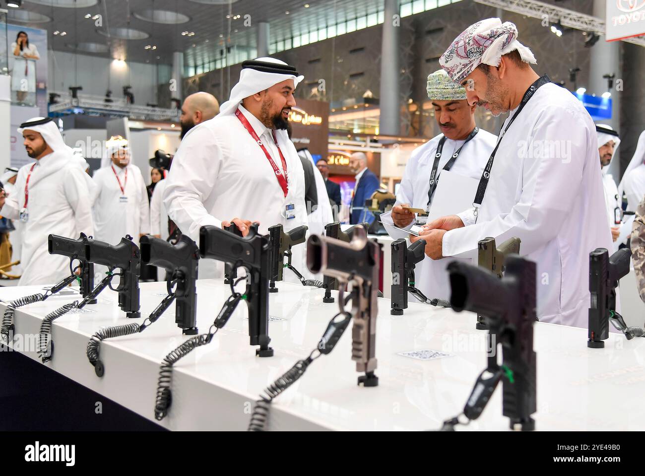 Doha, Qatar. 29th Oct, 2024. Visitors look at guns on display at ...