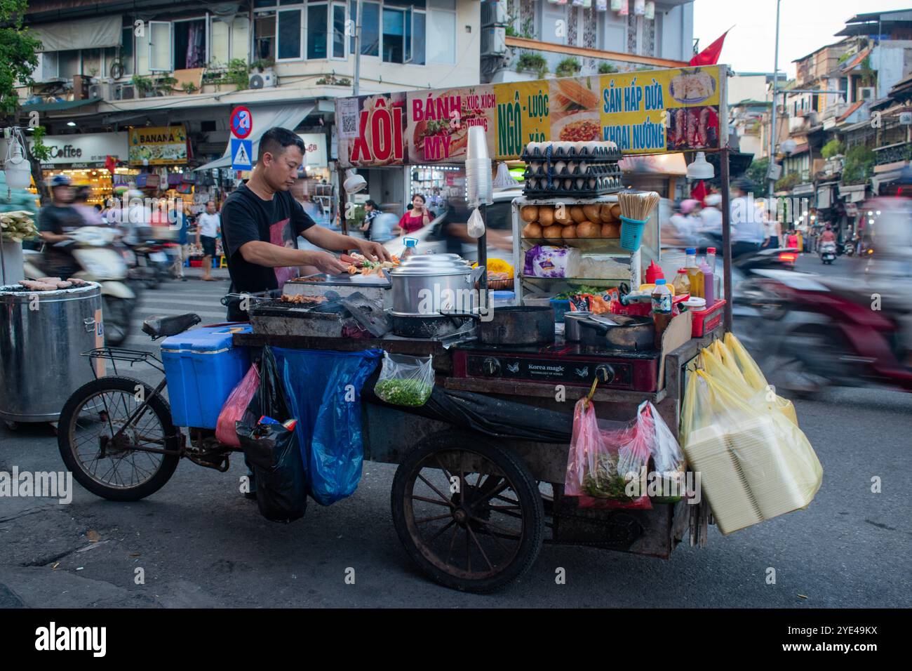 Hanoi, Vietnam: a Vietnamese man cooking food on his wheeled cart in ...