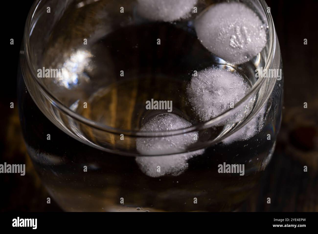 glass with cold sparkling water closeup, cold mineral water with a lot of gases and bubbles ...