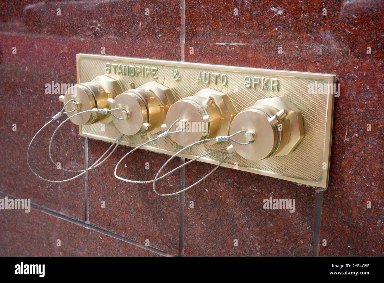 Brass standpipe and auto sprinkler unit on a red granite wall Stock ...