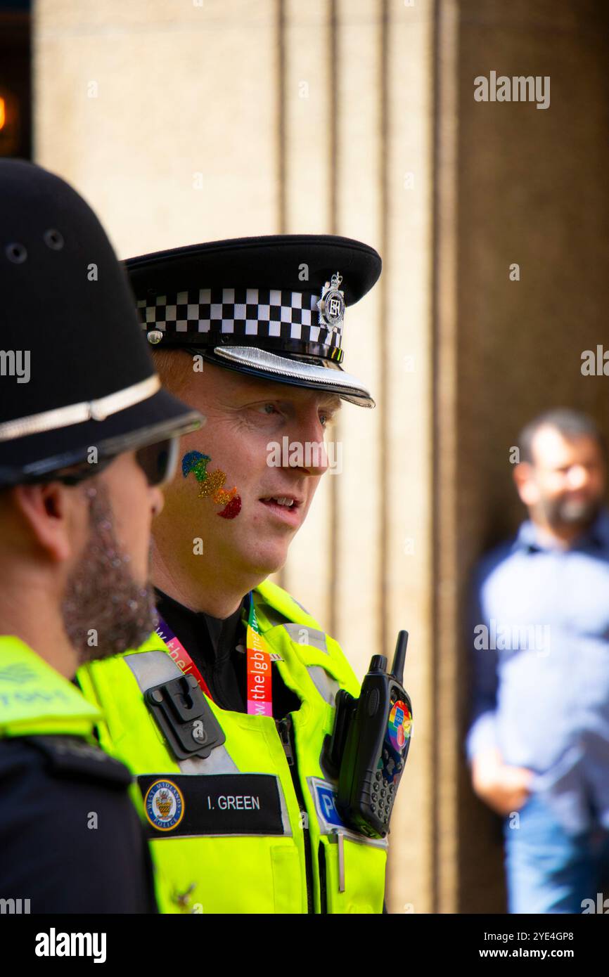 Police officers with rainbow face paint participate in a public event ...