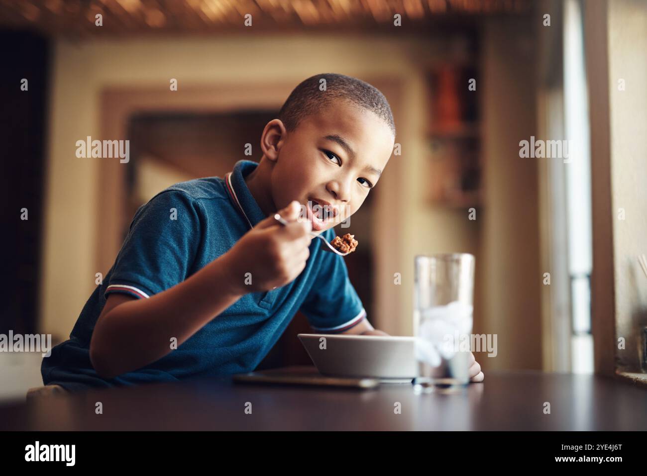 Kid, portrait and eating food in home for nutrition, hungry and healthy ...