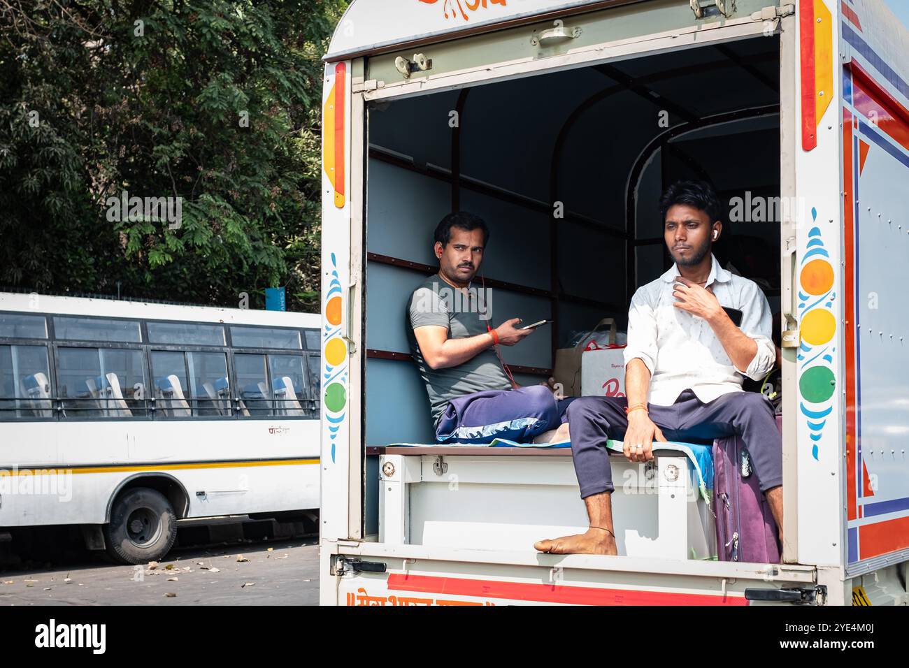 Indian men travelling on a truck in Mumbai India. Workers travel at the ...