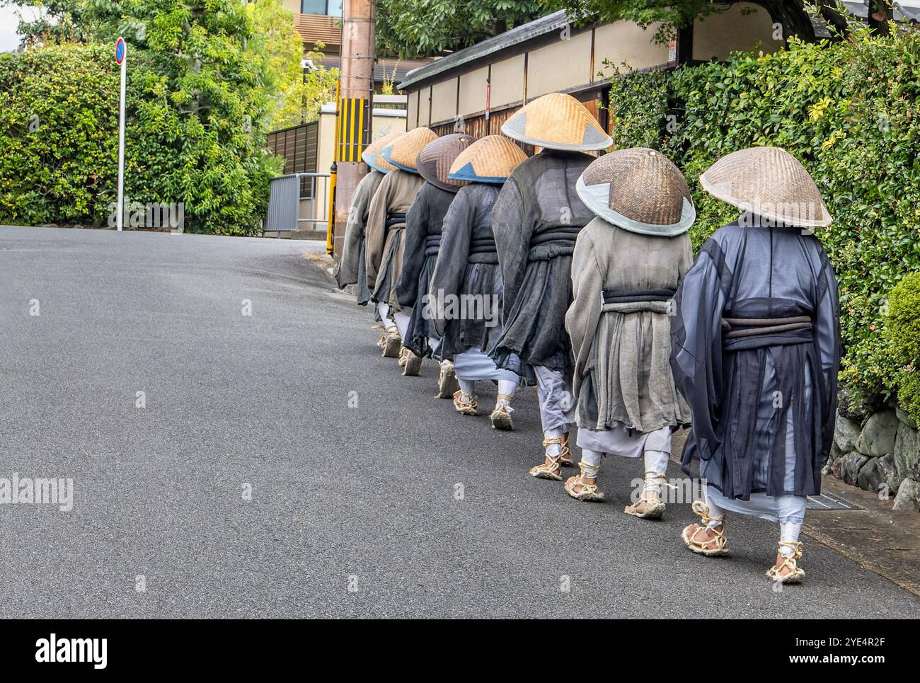 Procession of wandering buddhist monks walking in a line with straw ...