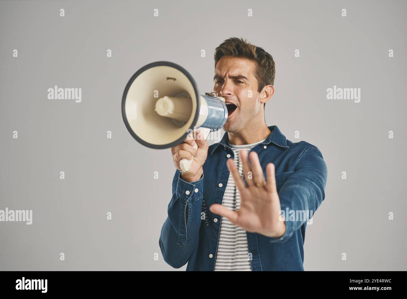 Man, shout and megaphone with stop in studio of communication ...