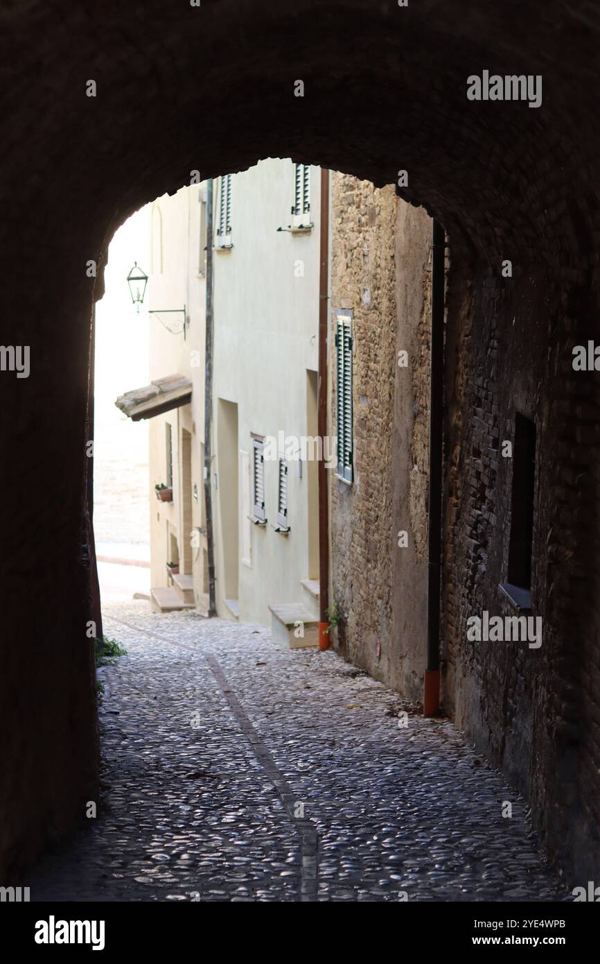 View through an archway along a narrow back street in an old town Stock ...