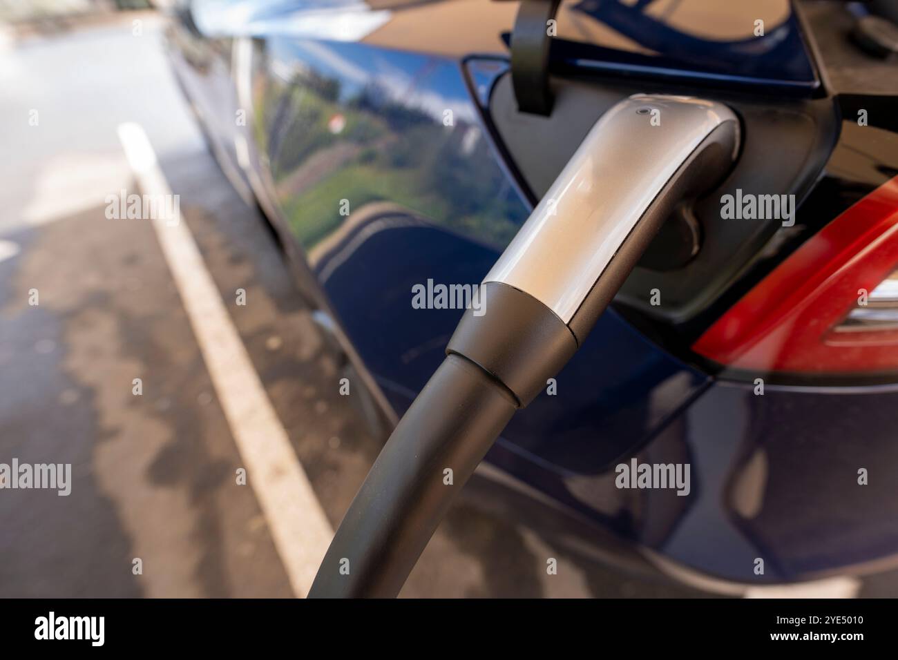 Charging hose of an electric car at a charging point Left rear corner ...