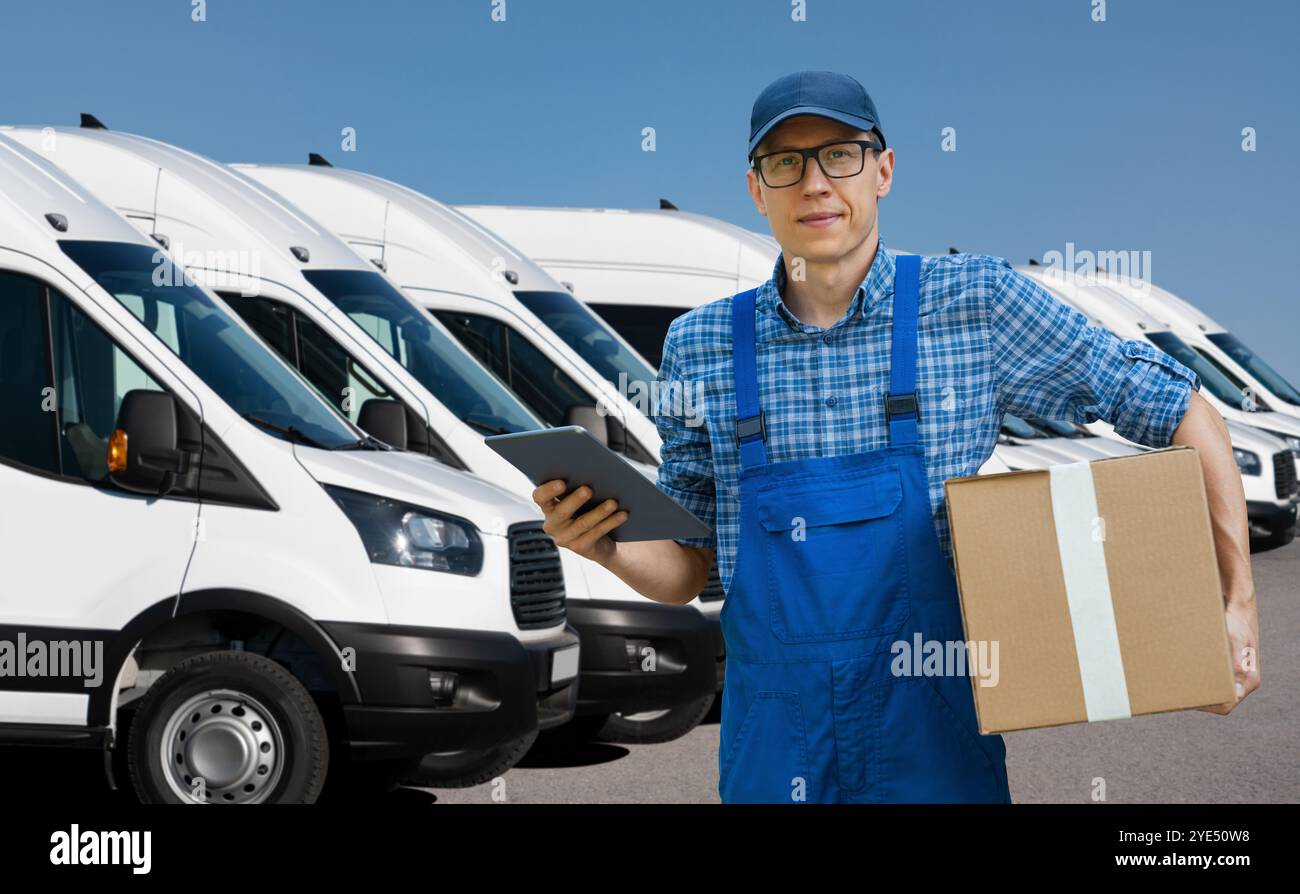 Delivery man in uniform with digital tablet Stock Photo - Alamy