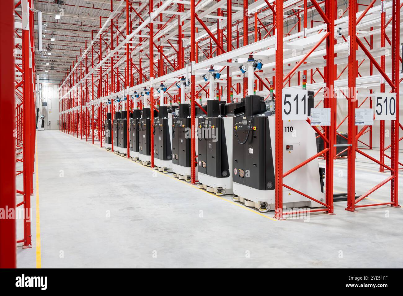 Modern automated guided vehicles AGV parked in a row under racks in high bay warehouse Stock ...