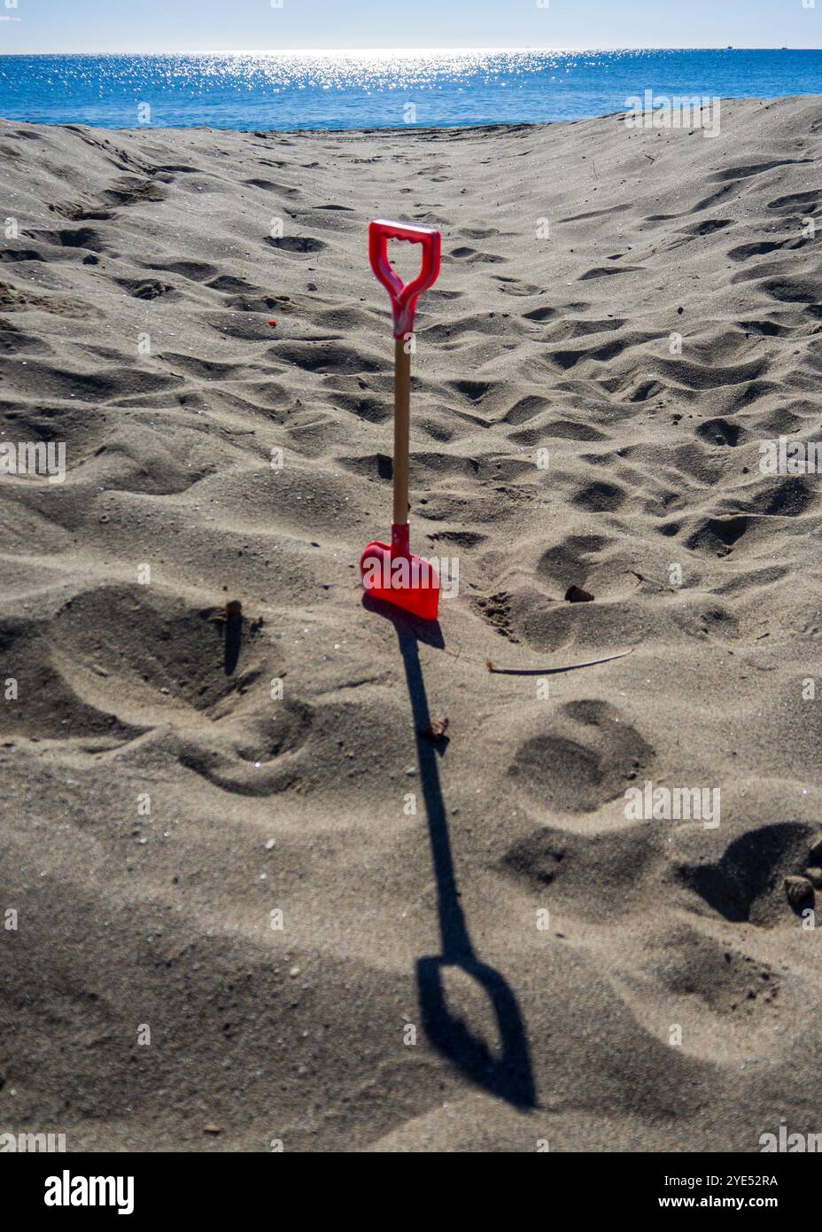 Small toy shovel on the beach in Benalmádena, Spain Stock Photo - Alamy