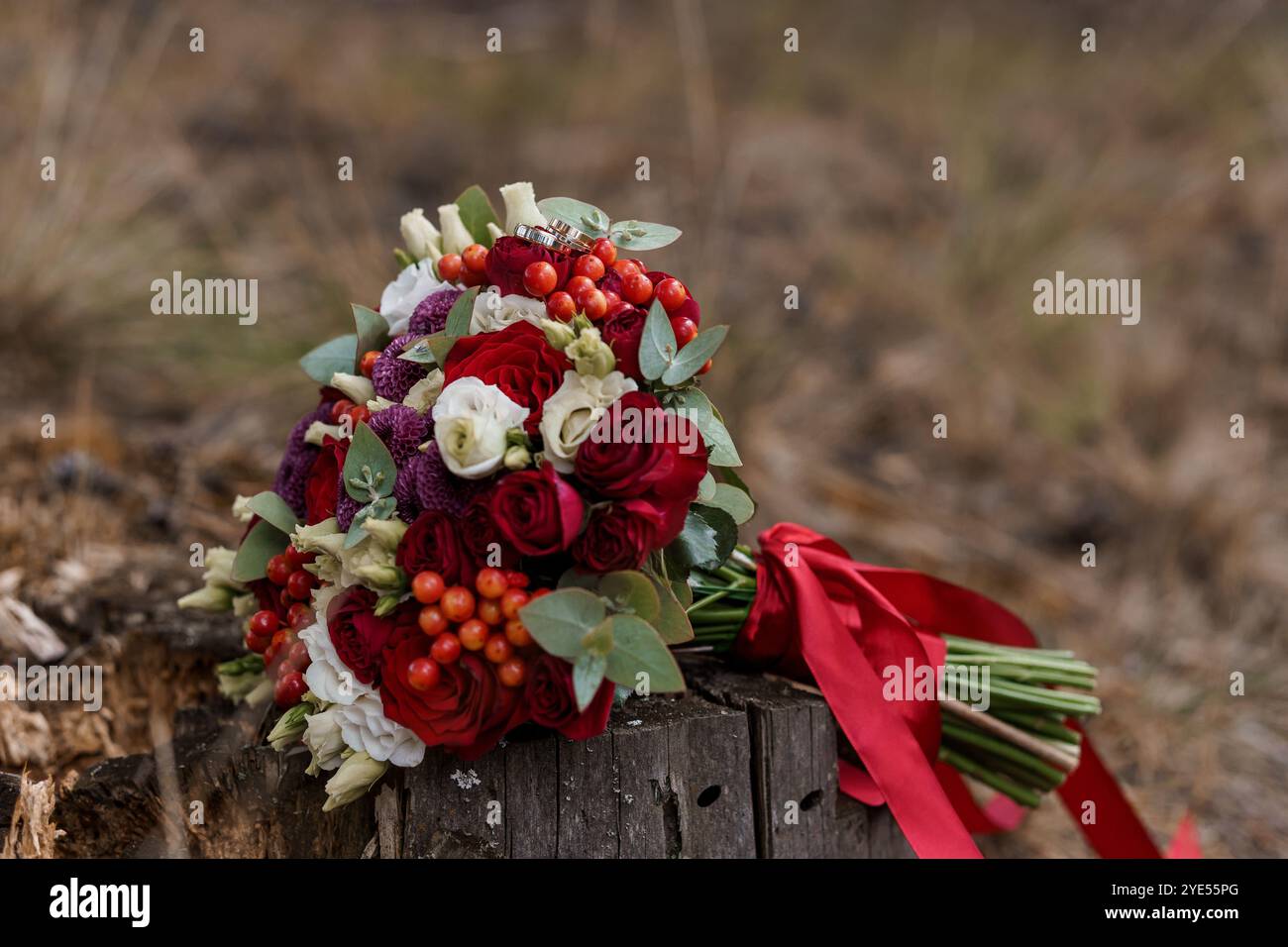 A Rustic Bridal Bouquet Featuring Red Roses and Seasonal Foliage Stock ...