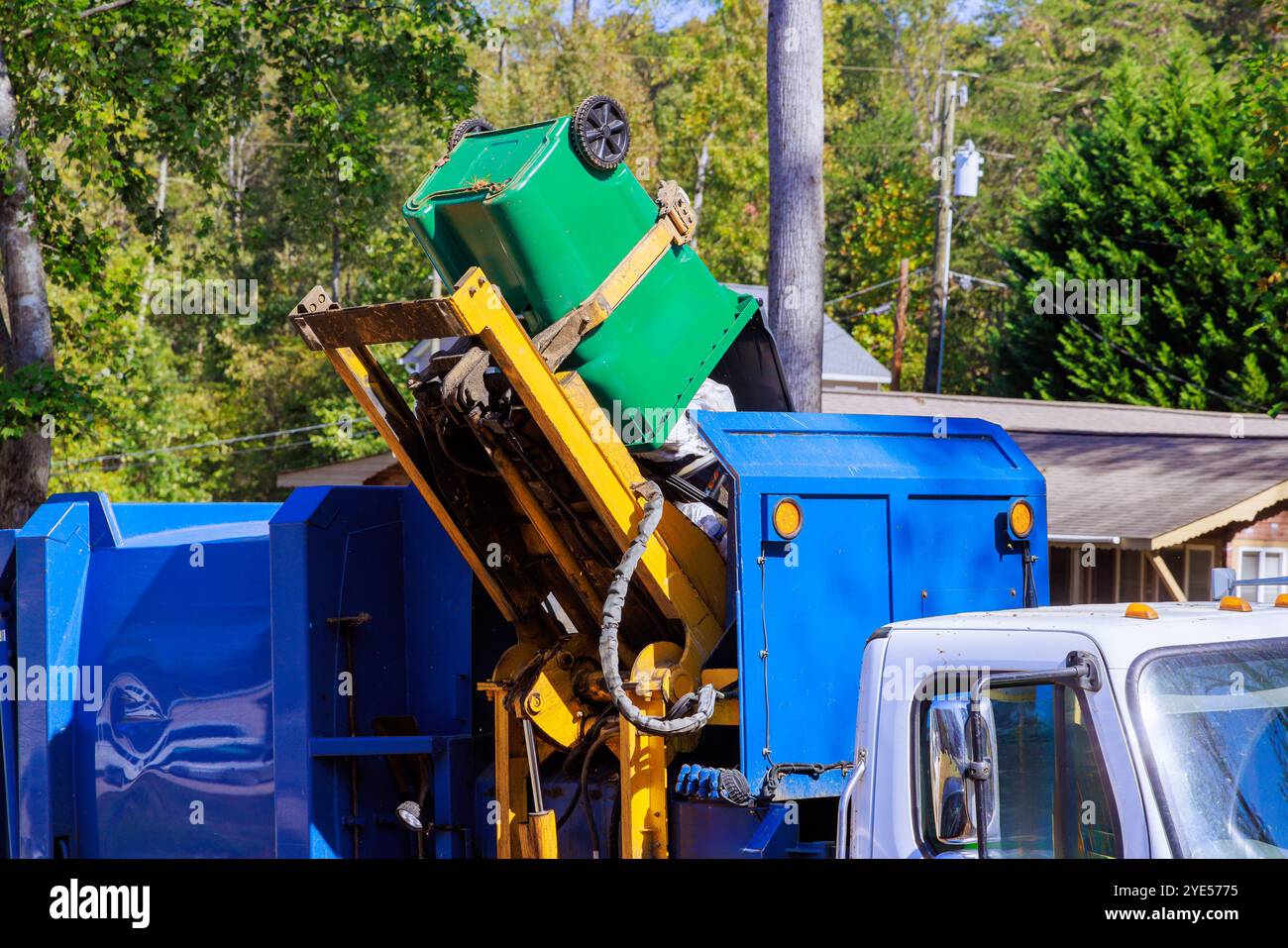 An employee of municipal cleaning service loads mixed domestic waste ...