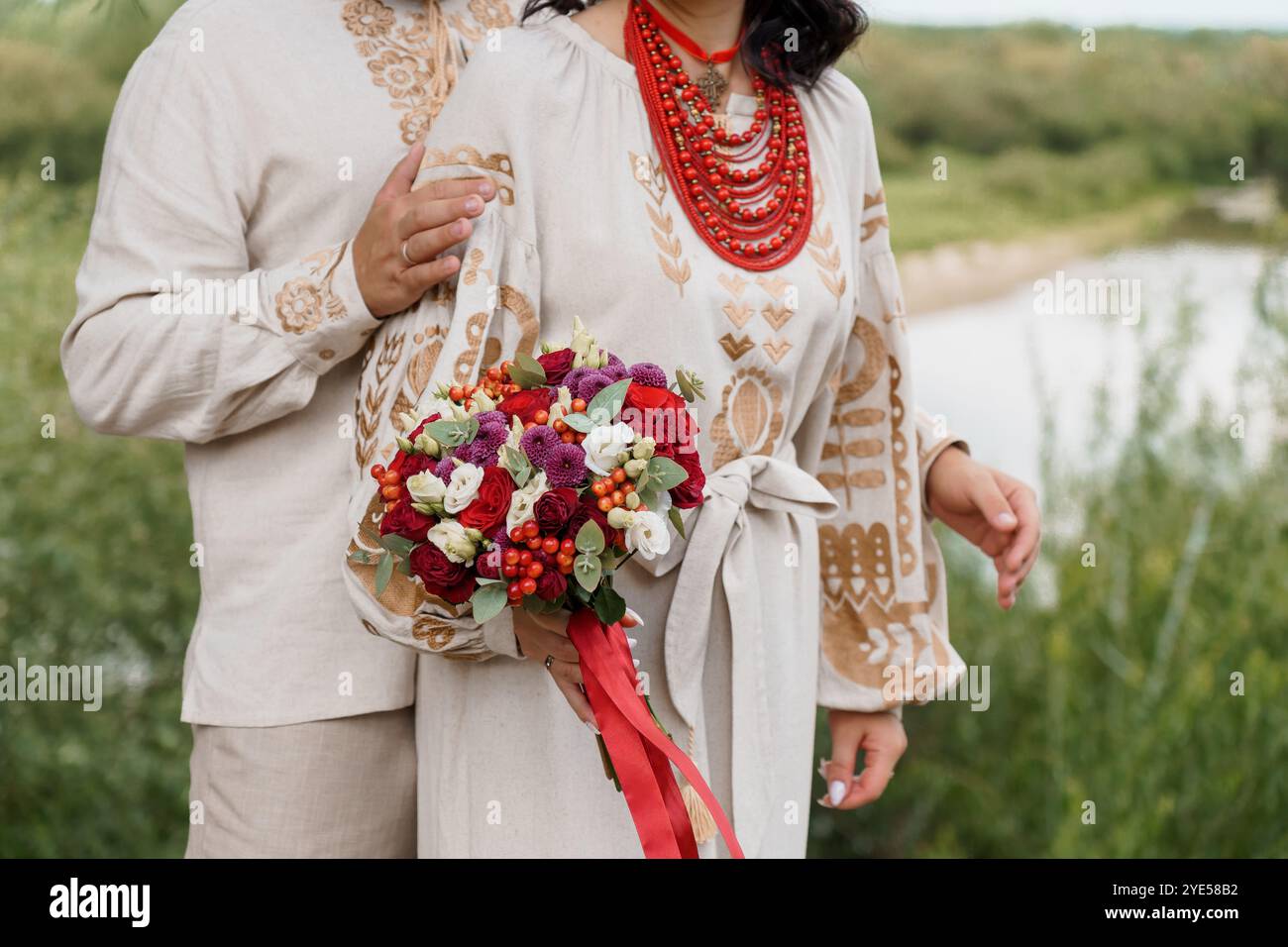 Elegant Couple in Traditional Attire Holding a Beautiful Bouquet by a ...