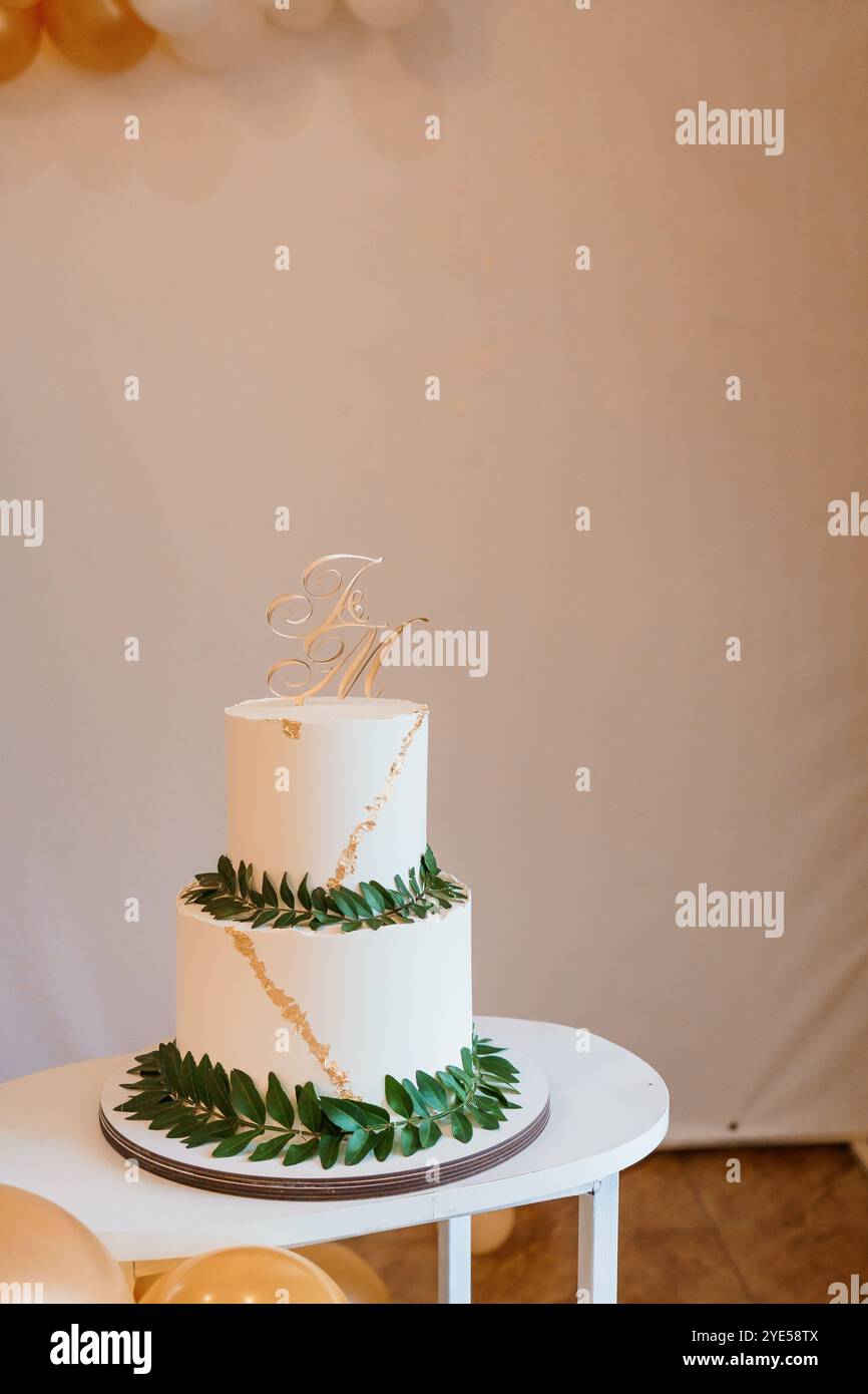 Elegant Three-Tier Wedding Cake with Gold Accents and Greenery ...