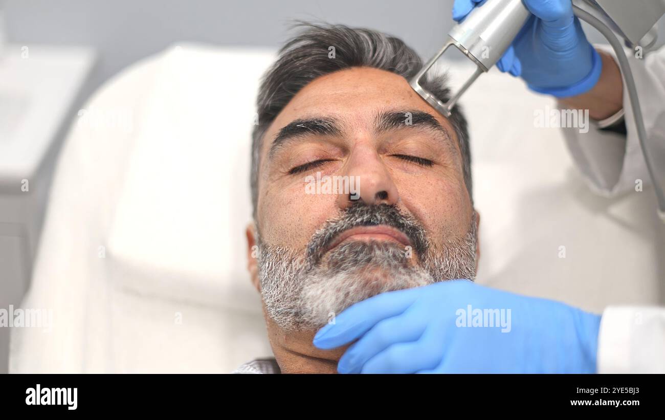 Male patient receiving an advanced skin treatment at a beauty clinic ...