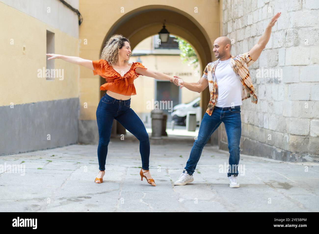 Cuban dancers engage in a vibrant Latin dance routine in a sunny urban ...