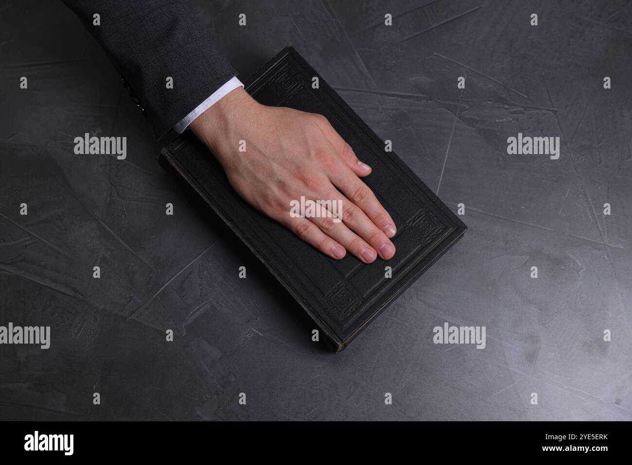 Man taking oath with his hand on Bible at black table, above view Stock ...