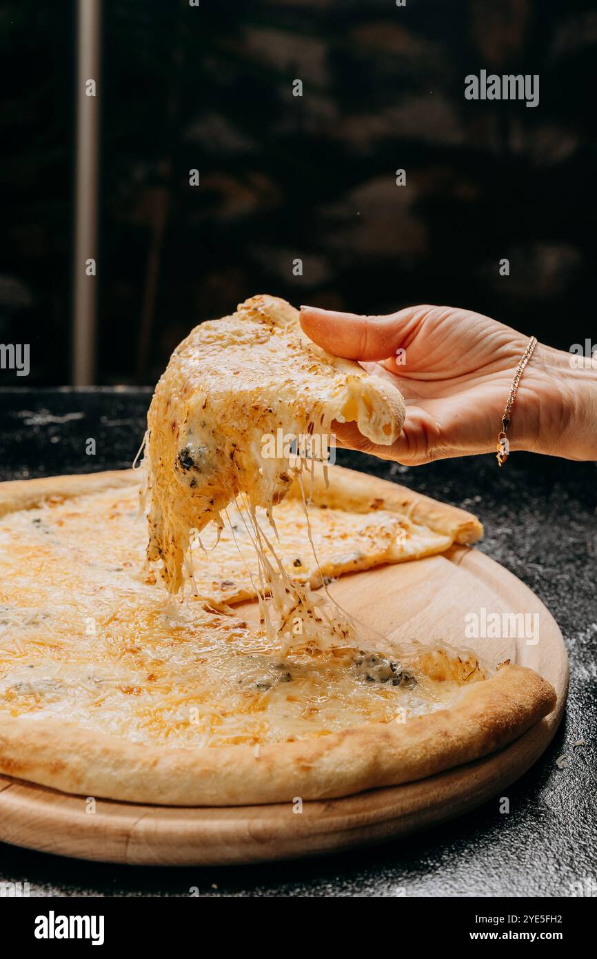 Melting cheesy pizza slice being lifted, showcasing gooey cheese pull ...