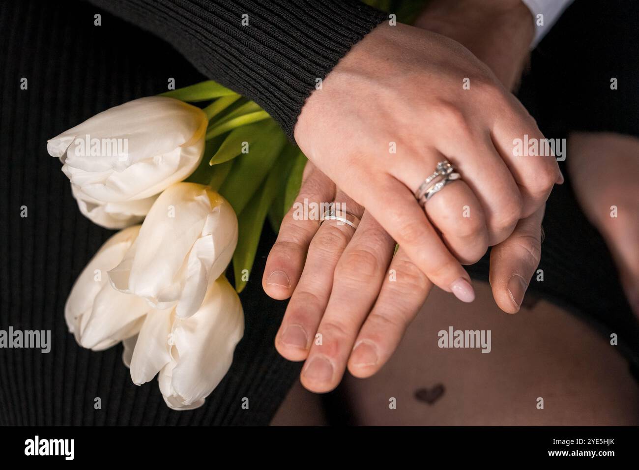 Romantic Gesture of Commitment with White Tulips and Intertwined Hands ...