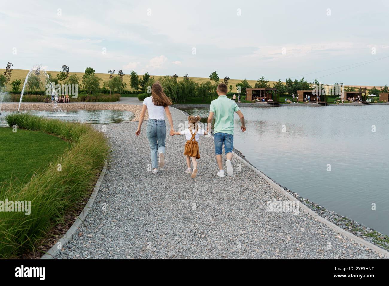 Family Strolling Along Scenic Lakeside Pathway Stock Photo - Alamy