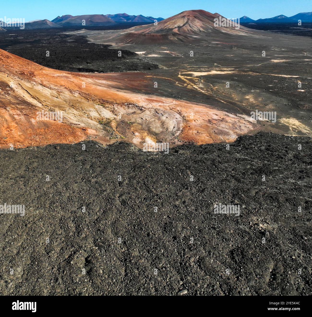 A red mountain, black volcanic ground and lava formations, volcanoes ...