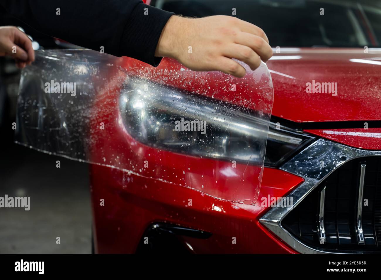 The process of applying protective vinyl film to car headlights in ...