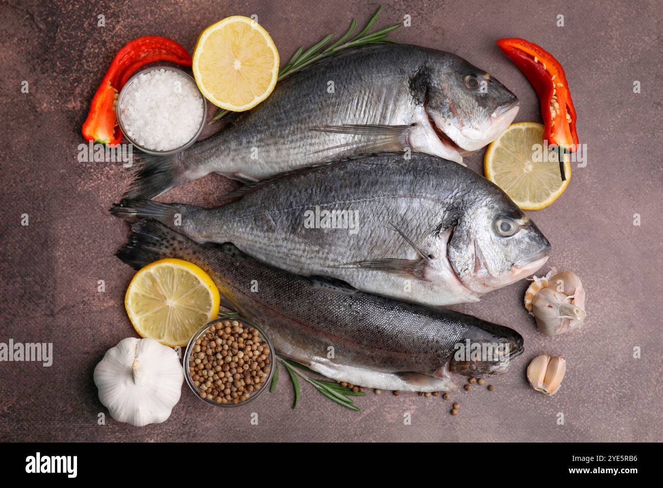 Sea food. Different types of raw fish and products on brown table, flat ...