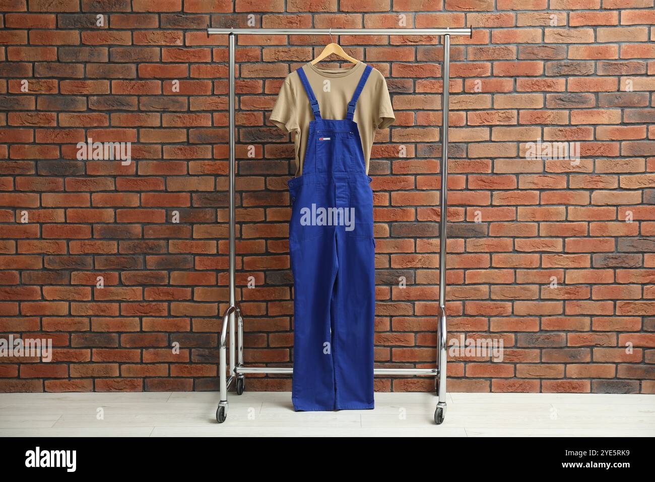 Workers' uniform on clothing rack near brick wall Stock Photo - Alamy