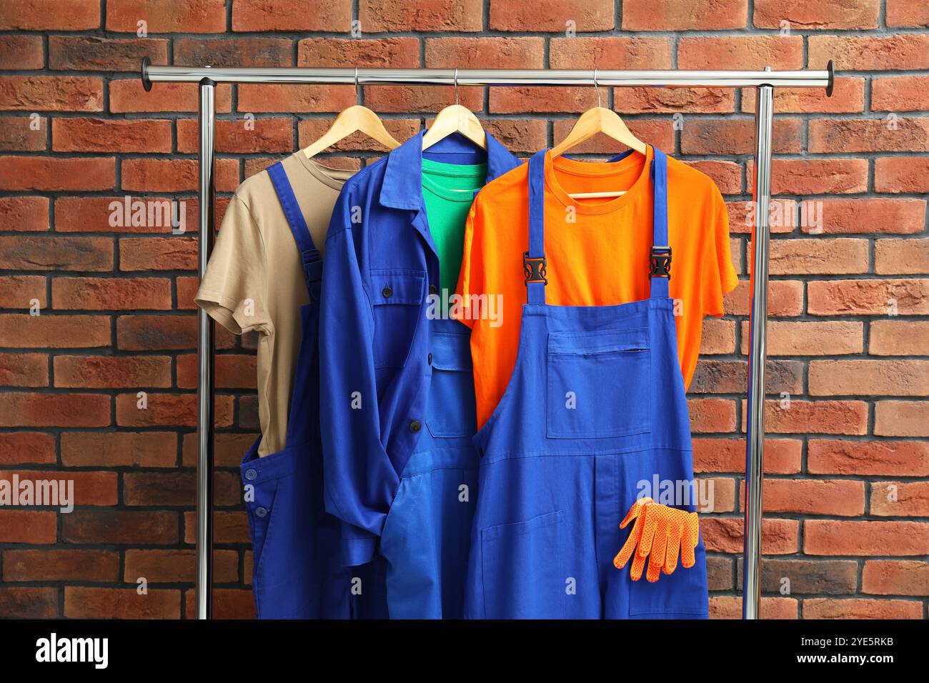 Different workers' uniforms on clothing rack near brick wall Stock ...
