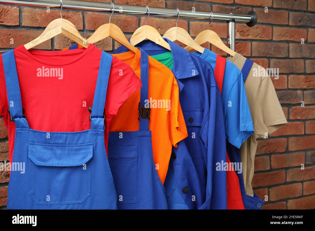Different workers' uniforms on clothing rack near brick wall Stock ...