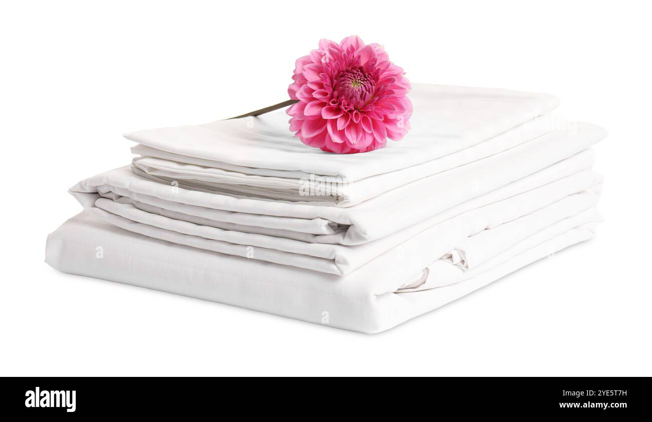 Stacked bed linens and pink flower on white background Stock Photo - Alamy